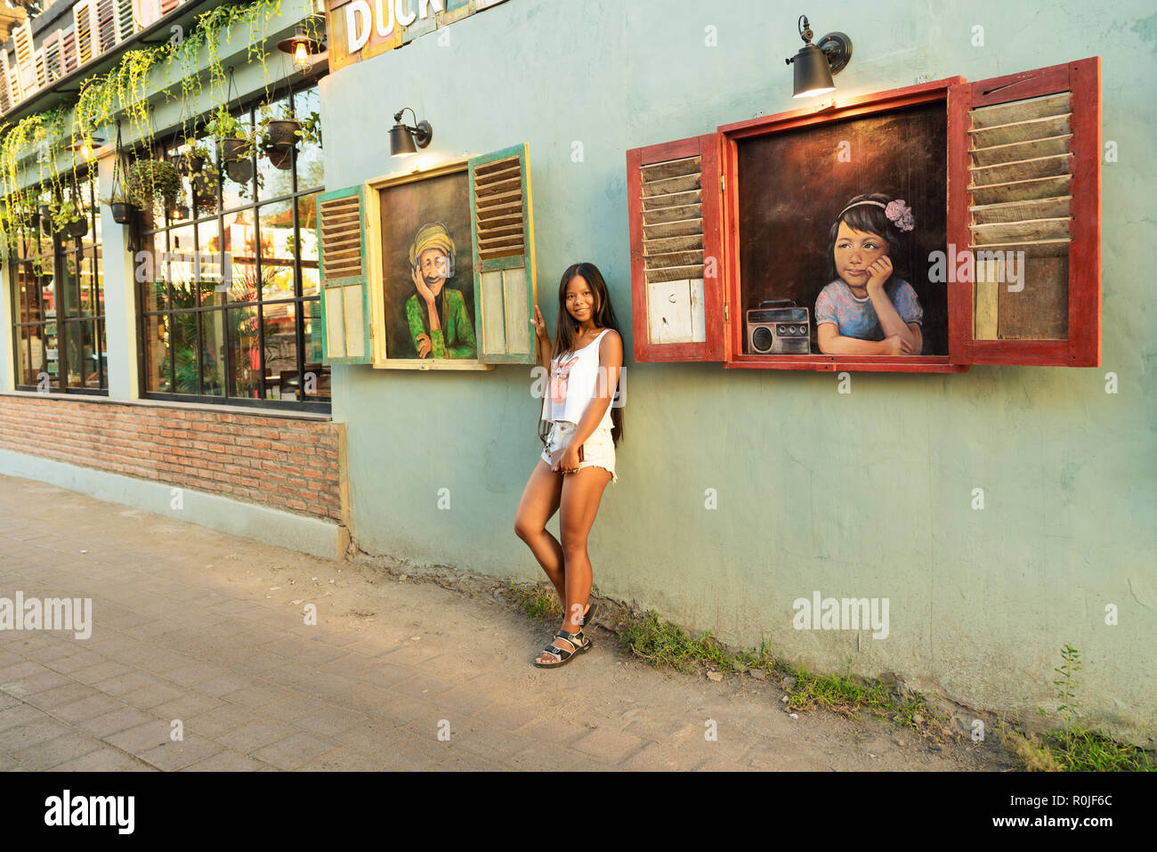 Traveling tourist girl walks through the picturesque street tropical ...