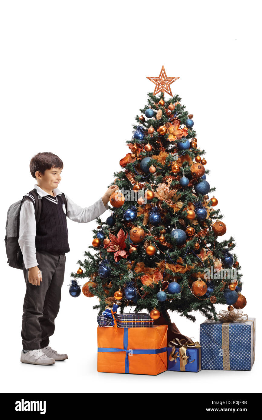 Full length profile shot of a schoolboy decorating a Christmas tree ...