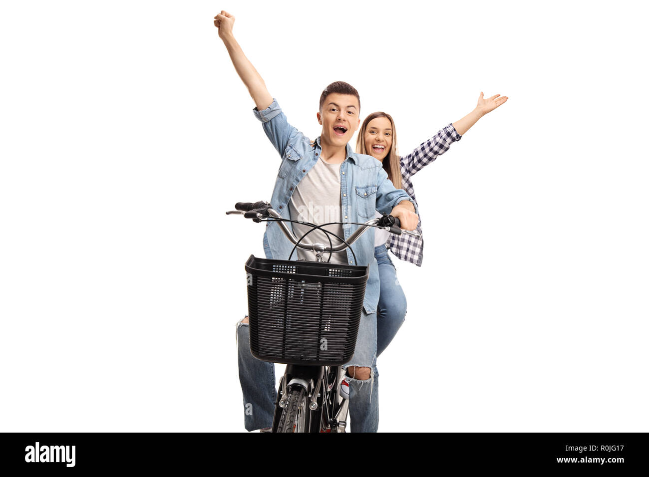 Cheerful teenage boy and girl riding on a bike and raising hands up ...