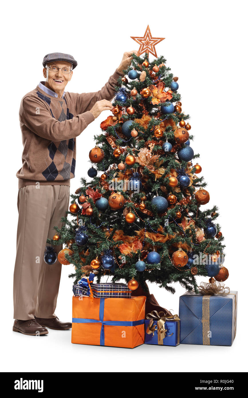Full length portrait of a senior man decorating a Christmas tree ...