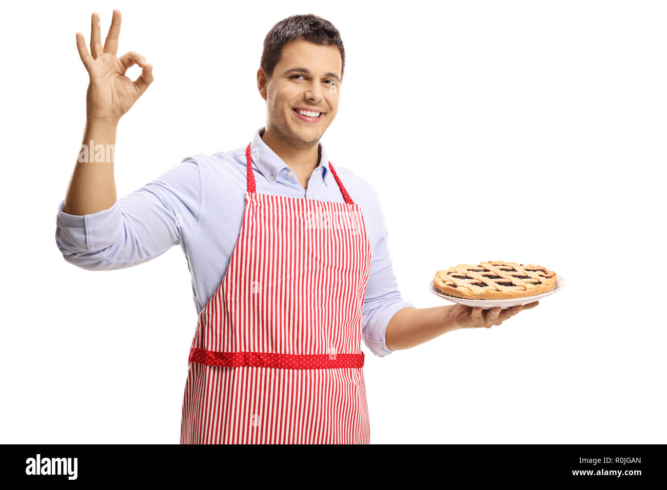 Young man holding a pie and gesturing perfect with hand isolated on ...