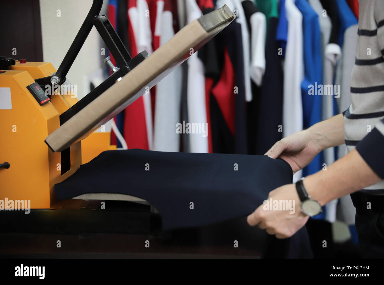 Man preparing t-shirt for printing in the silk screen printing machine ...