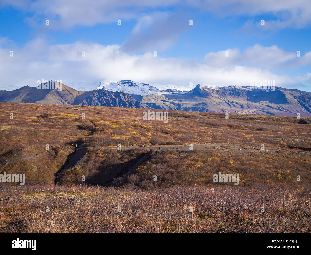 Icelandic landscape with tourists and with a snowy mountain top on ...