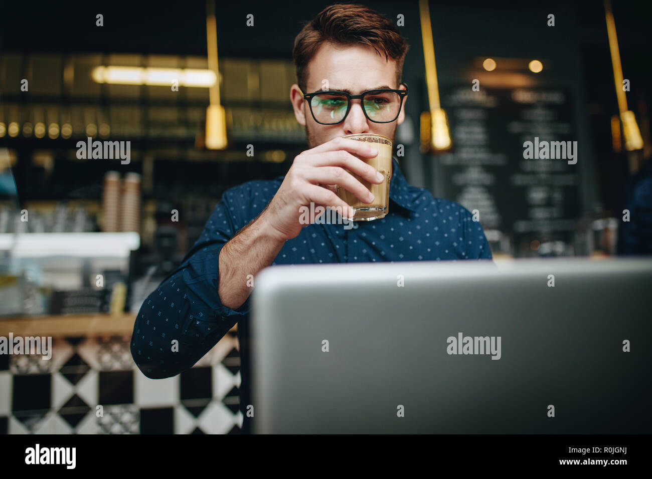 businessman working on laptop computer and drinking coffee sitting in a ...