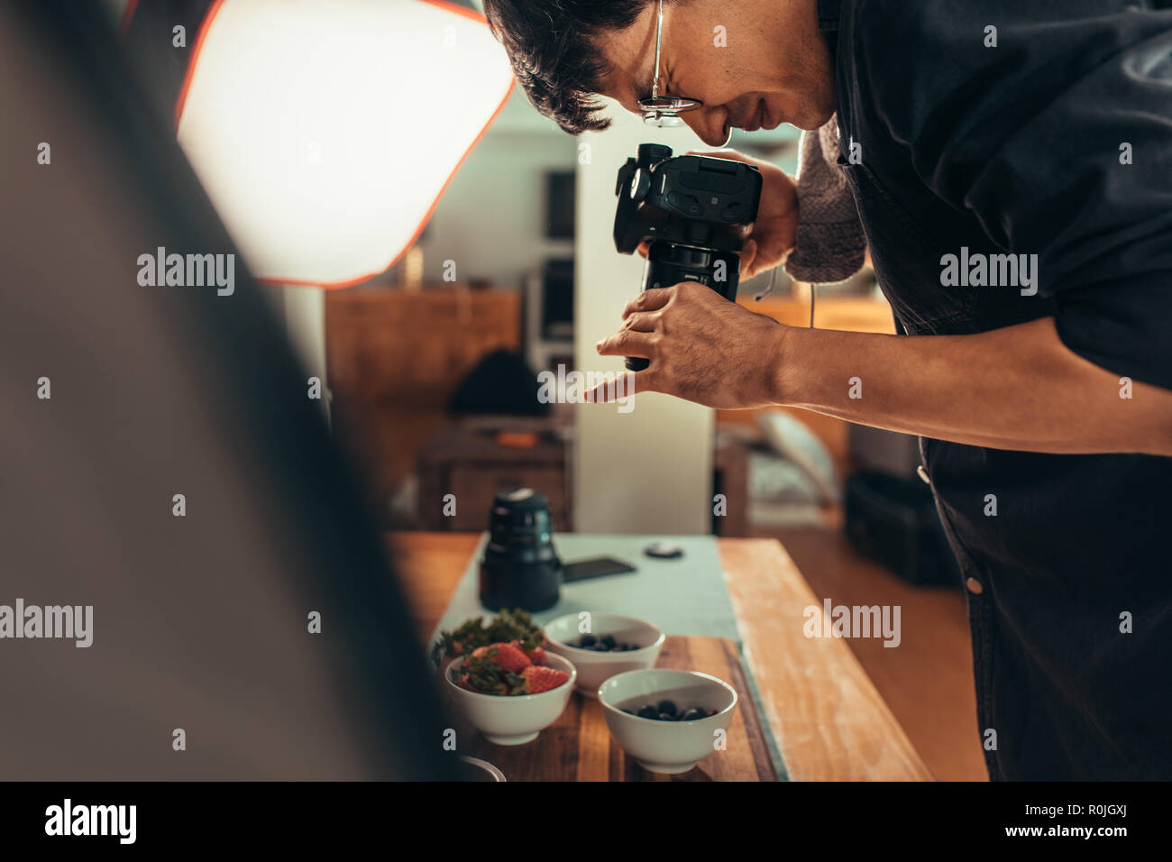 Male photographer shooting food on table. Professional food ...