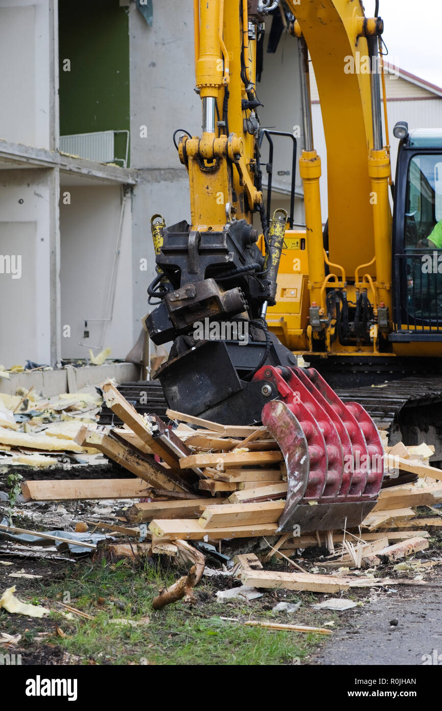 Excavator with grab breaking down a house Stock Photo - Alamy