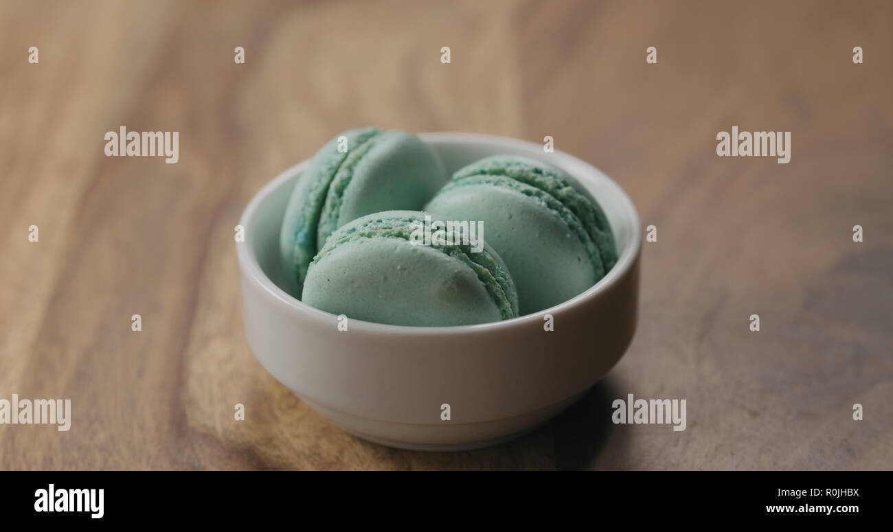 light blue macarons in white bowl on wood table, wide photo Stock Photo ...