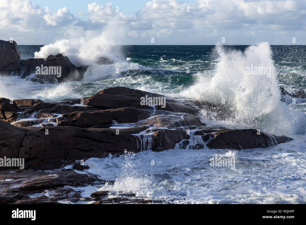 Rough sea and big waves hit rocks under friendly sky Stock Photo - Alamy