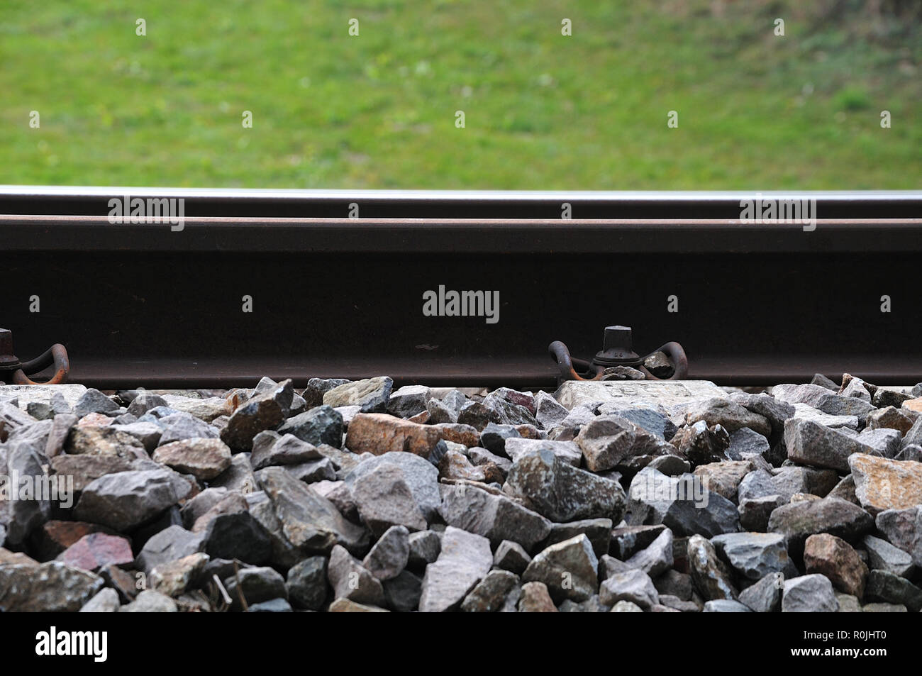 railroad track on gravel embankment with steel fixing mechanisms Stock ...