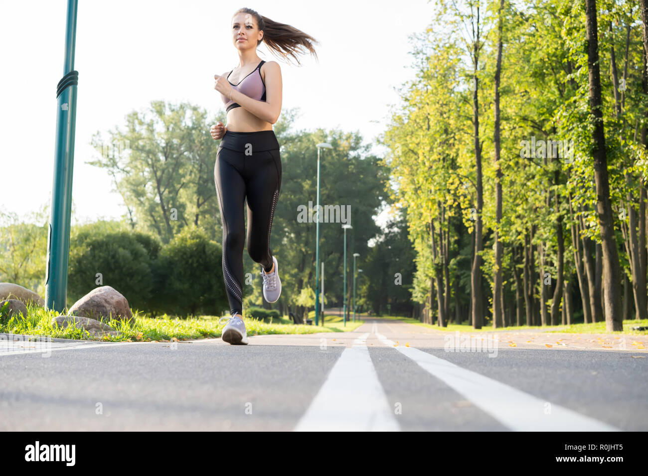 Young pretty woman with perfect slim body running outdoors. Fitness and ...