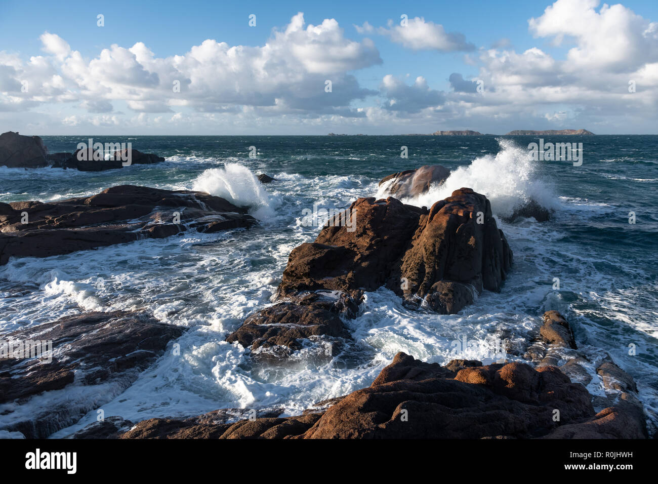 Rough sea and big waves hit rocks under friendly sky Stock Photo - Alamy