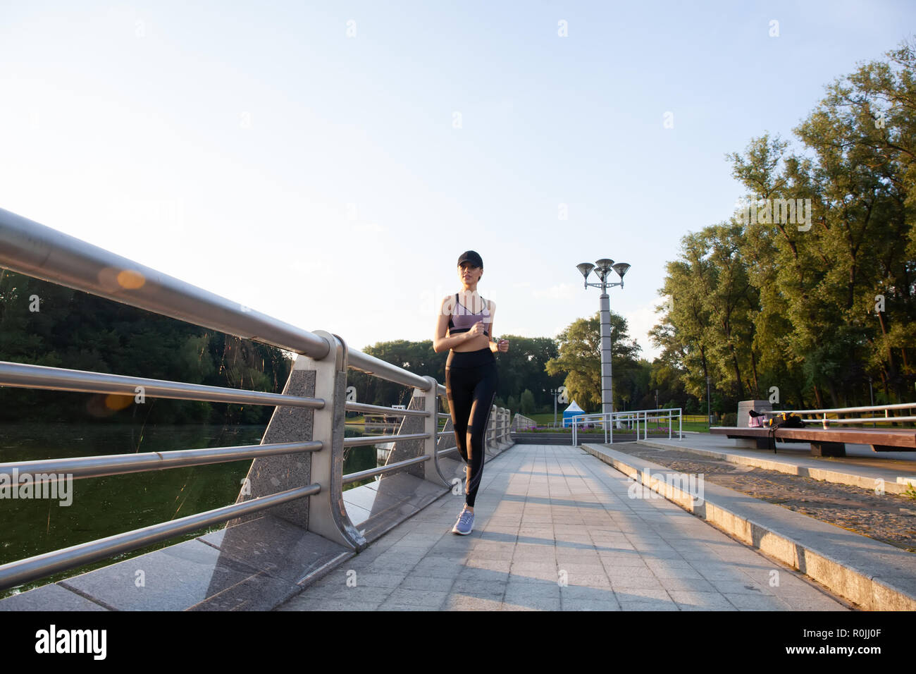 Young pretty woman with perfect slim body running outdoors. Fitness and ...