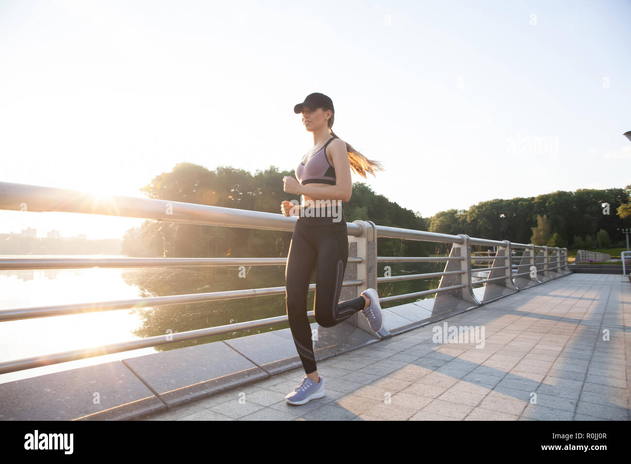 Young pretty woman with perfect slim body running outdoors. Fitness and ...