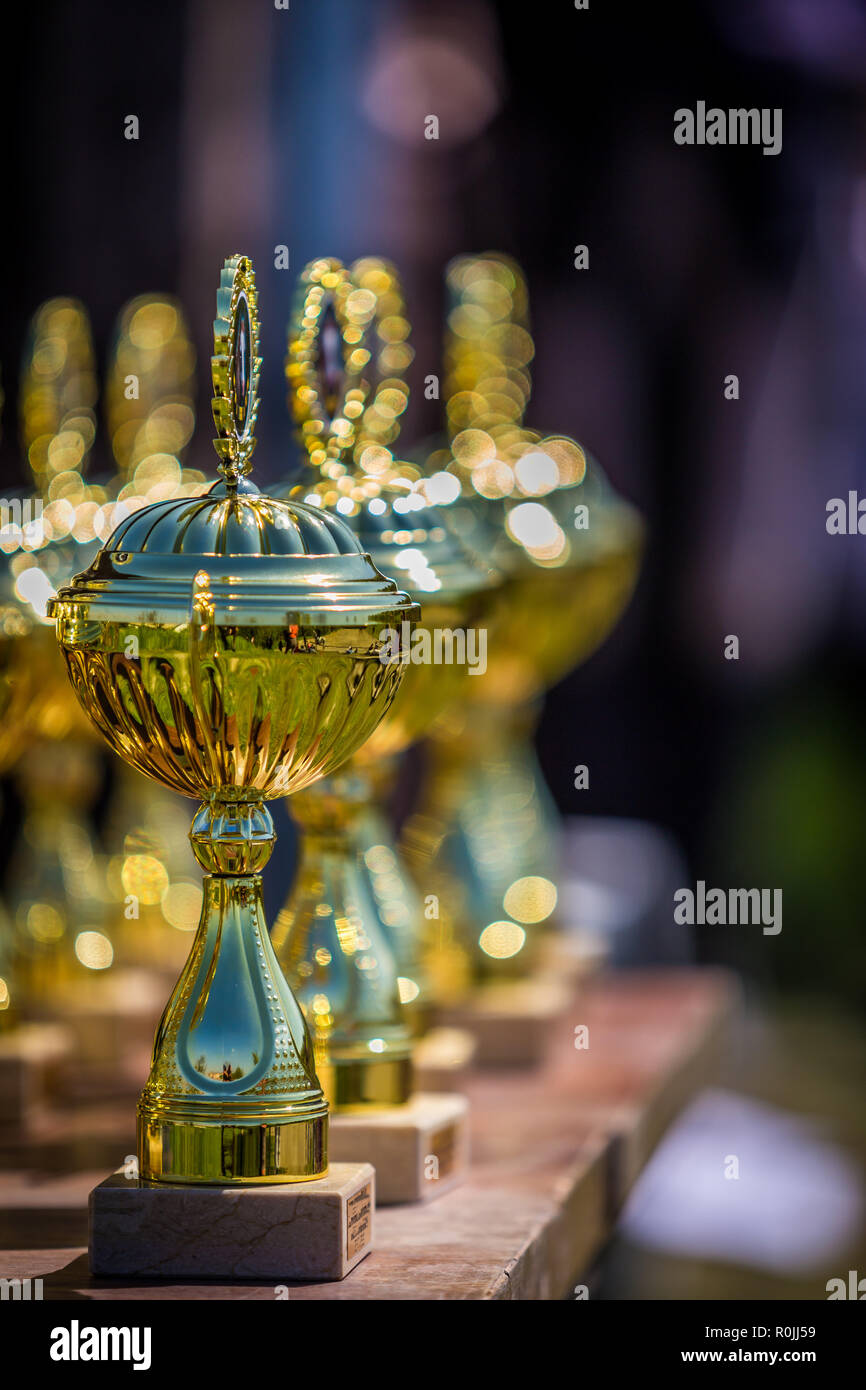 Shiny trophies line up on the table Stock Photo - Alamy