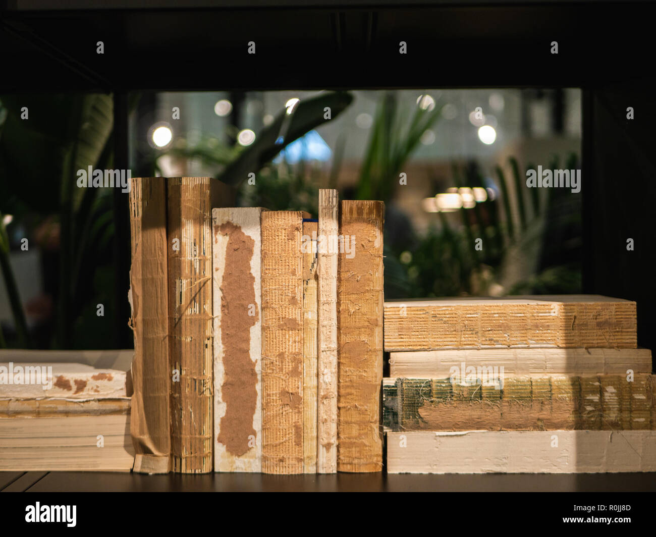 Old, worn out books standing on a black book shelf Stock Photo - Alamy