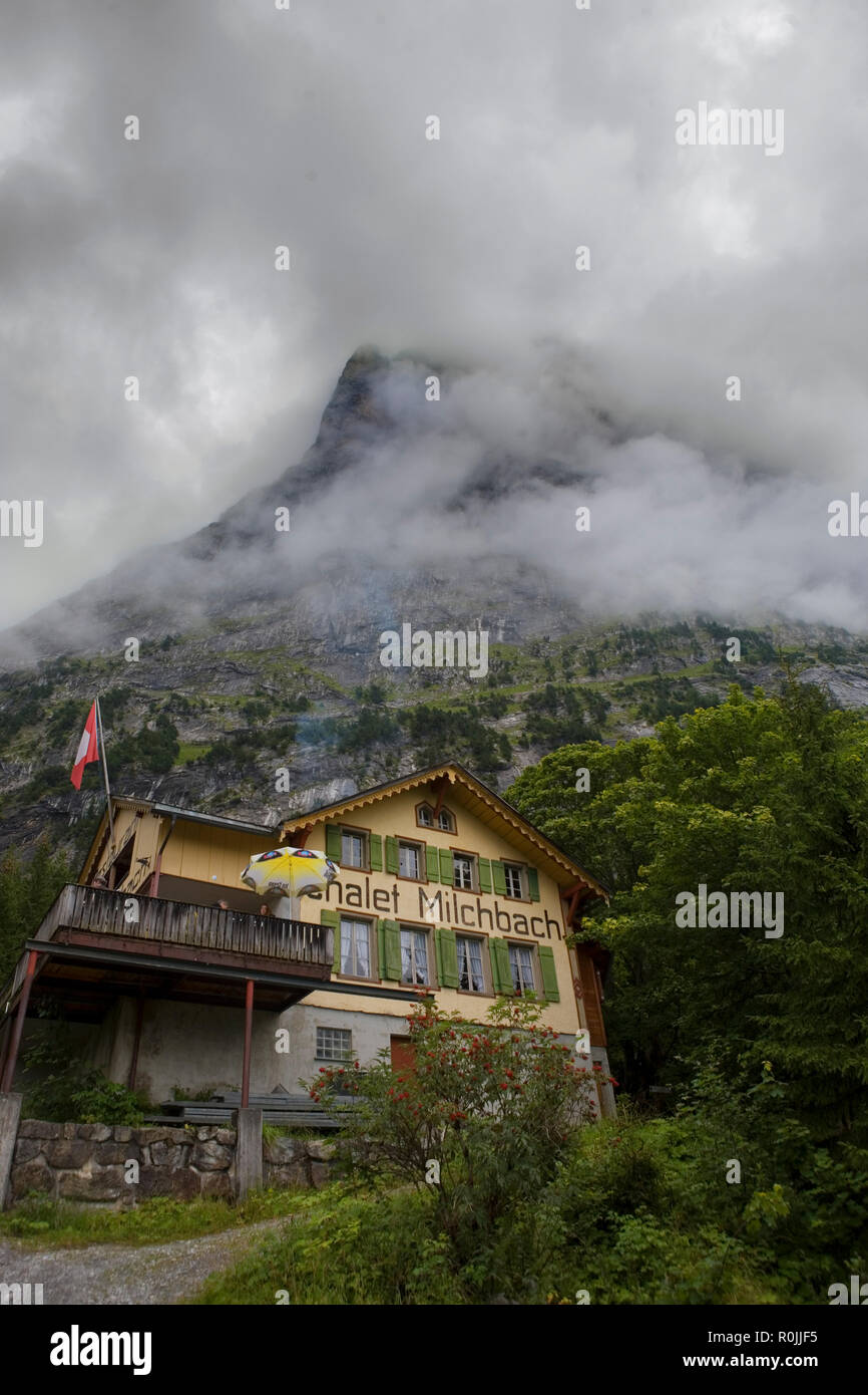 The Chalet Milchbach, dominated by the cloudy and precipitous wall of ...