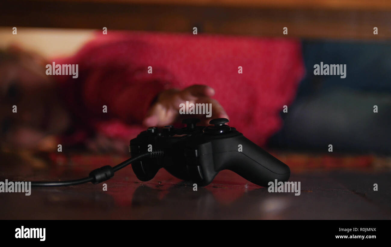 Joystick under the bed. Girl reaching for it. Close up Stock Photo - Alamy