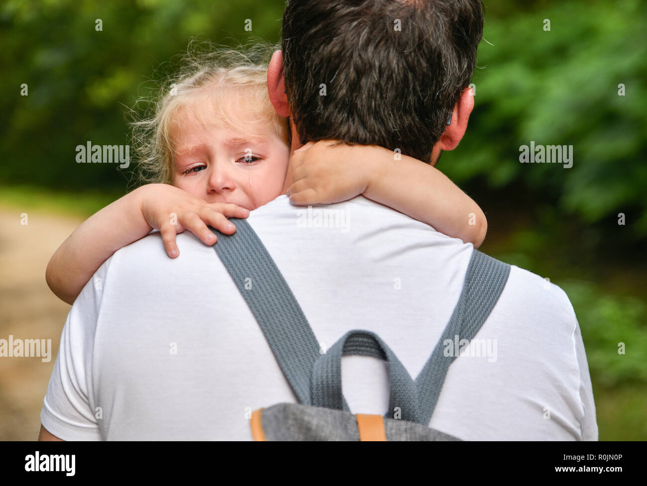 A little girl cries and hugs father Stock Photo - Alamy