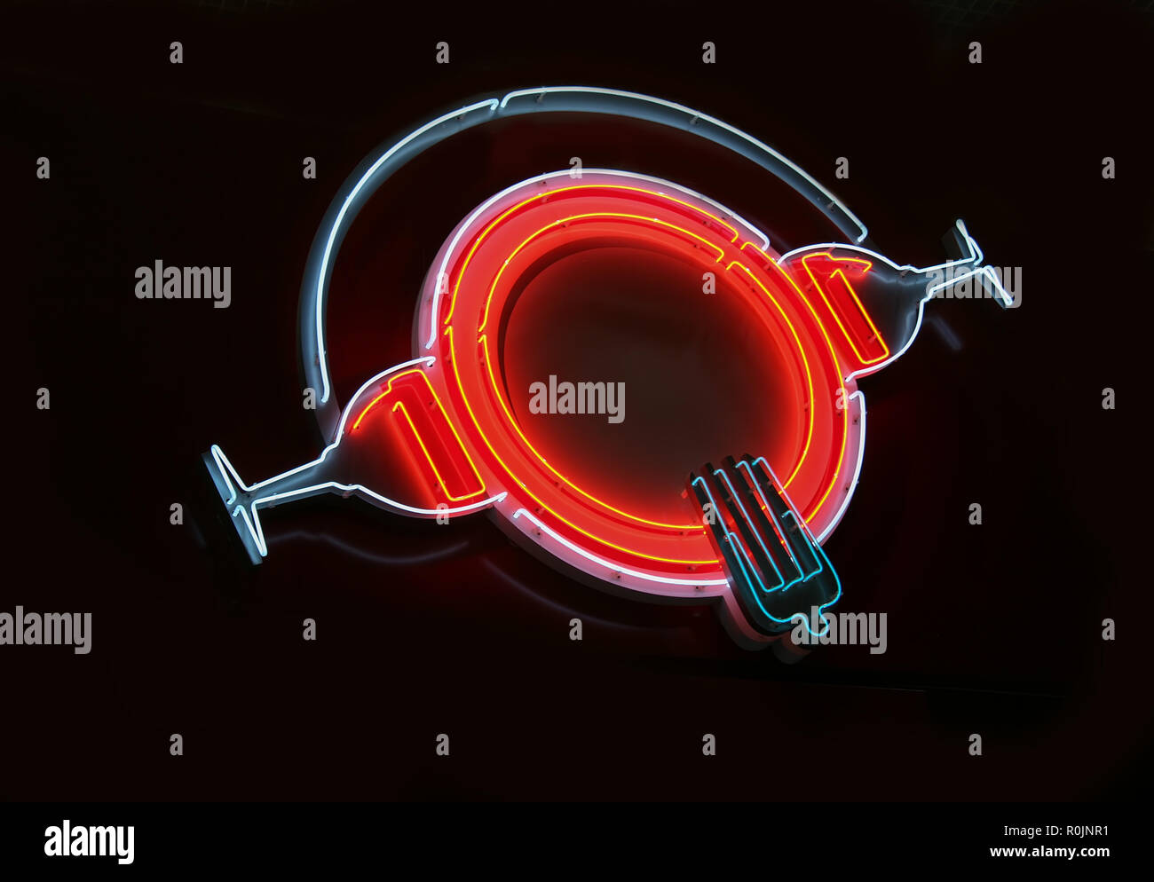 Neon luminous sign in the form of a plate of wine glasses and forks ...