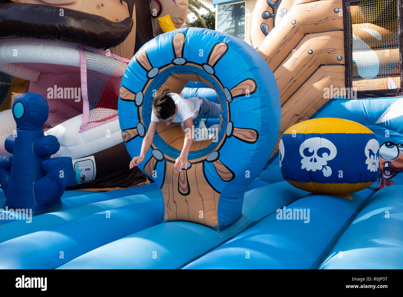 Boy jumping through a ring at an inflatable playground in Spain Stock ...