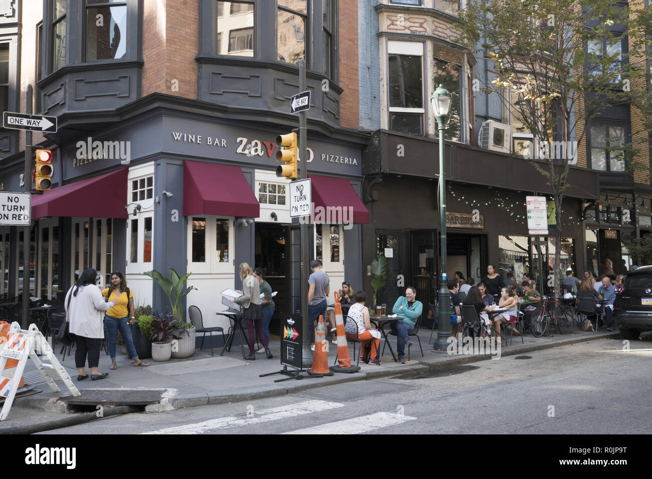 People relax at outdoor cafes and other establishments on Sansom Street ...