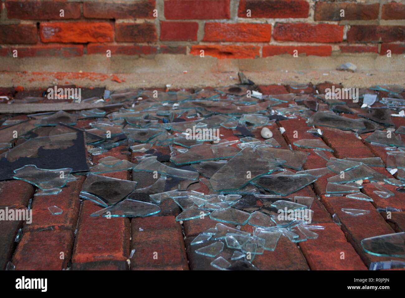 Close up of a pile of broken glass on a brick walkway Stock Photo - Alamy