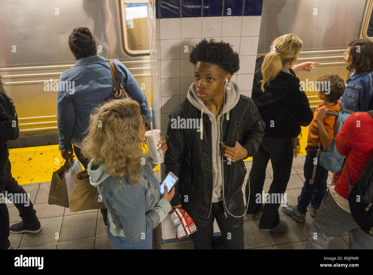 Two high school age teens wait for a subway train at Jay Street ...