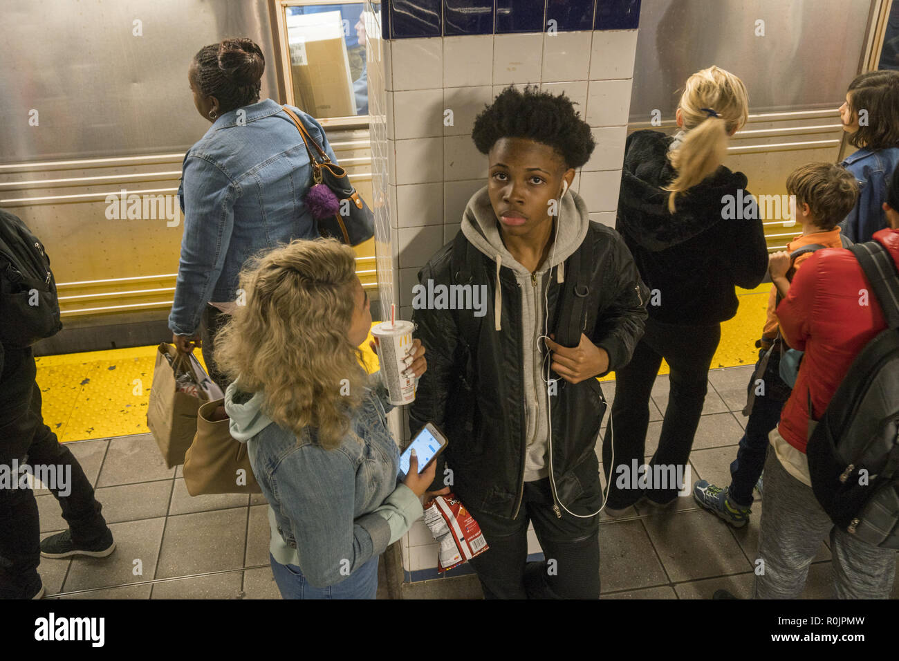 Two high school age teens wait for a subway train at Jay Street ...