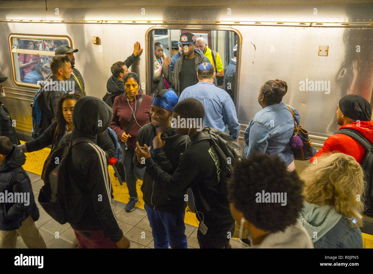 Teens talking on the subway train platform after school at the Jay ...