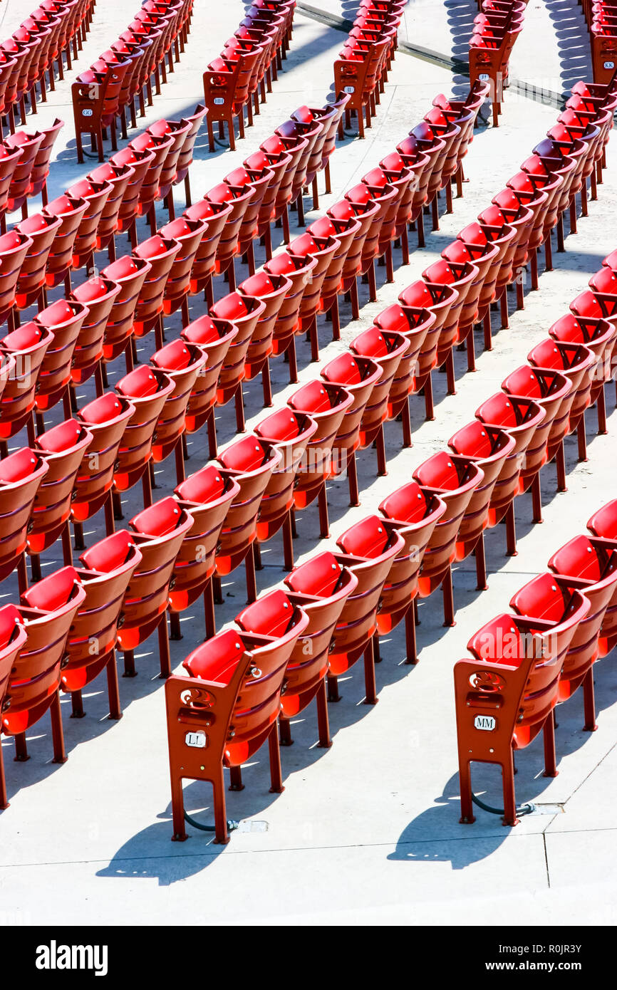 Numbered rows of red plastic seats over white concrete in an outdoor ...