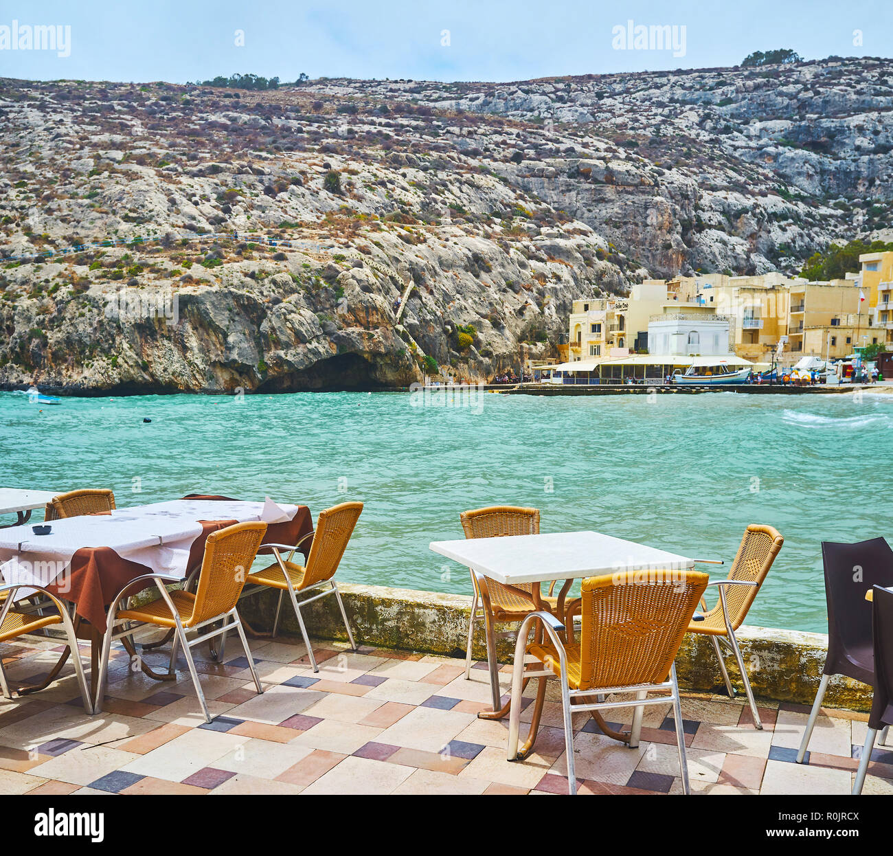 The small tables of outdoor coastal restaurant, located in narrow ...
