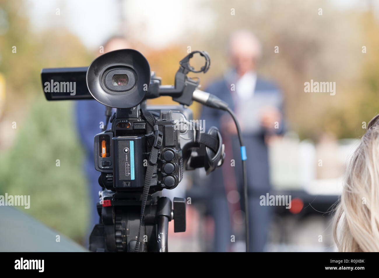 Shooting a media event with video camera. Closeup of a video camera at ...