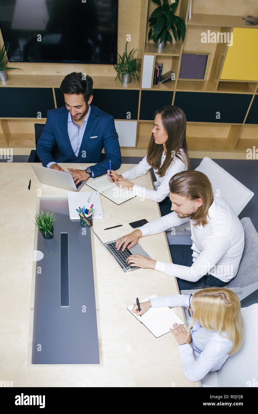 Young business people using computers and smiling while working in ...