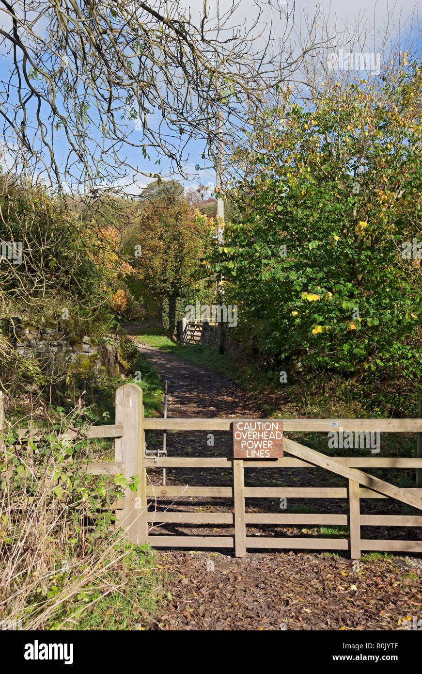 Caution overhead power lines sign attached to wooden gate North ...