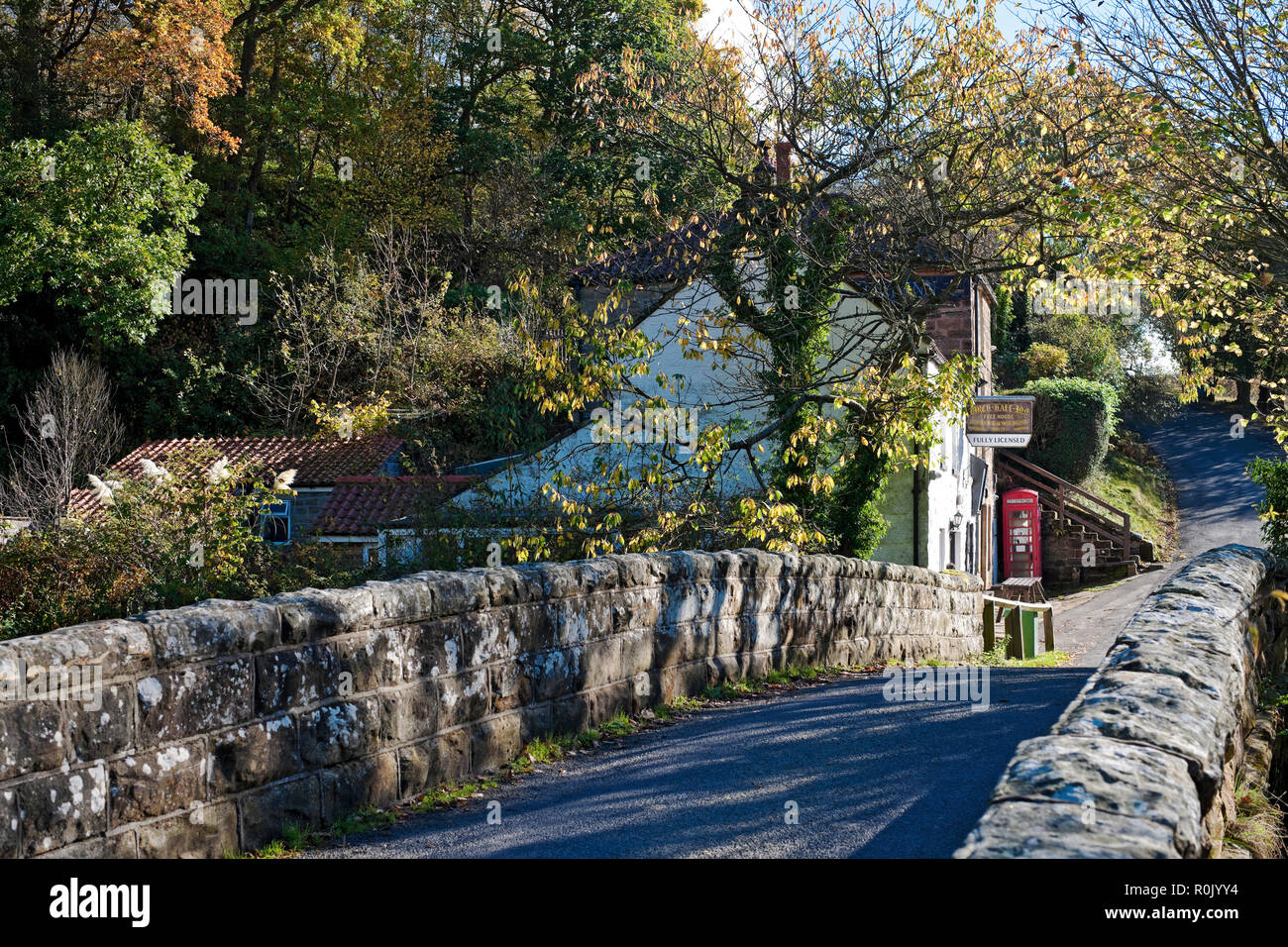 Looking across the bridge to Birch Hall Inn village pub in autumn Beck ...