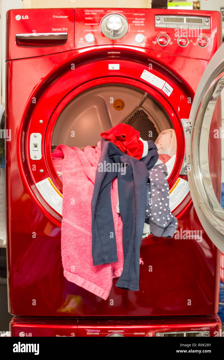 Laundry overflowing from an open dryer Stock Photo - Alamy