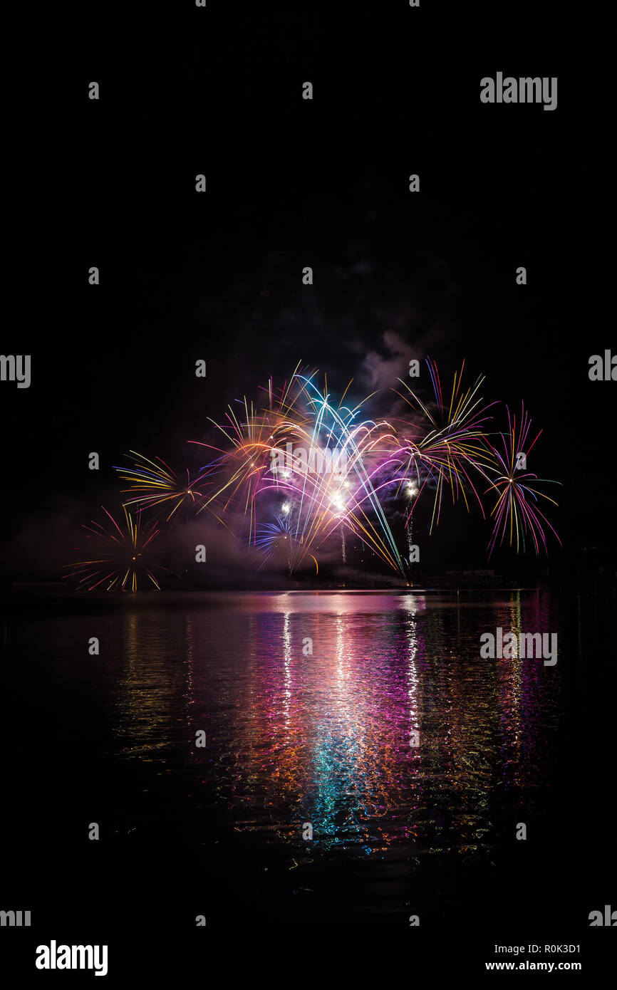 Long colorful tails of fireworks over surface Brno's Dam with lake ...