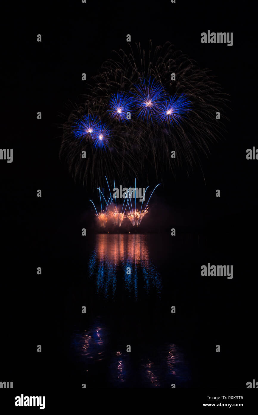Orange fountain and blue stars fireworks over Brno's Dam with lake ...