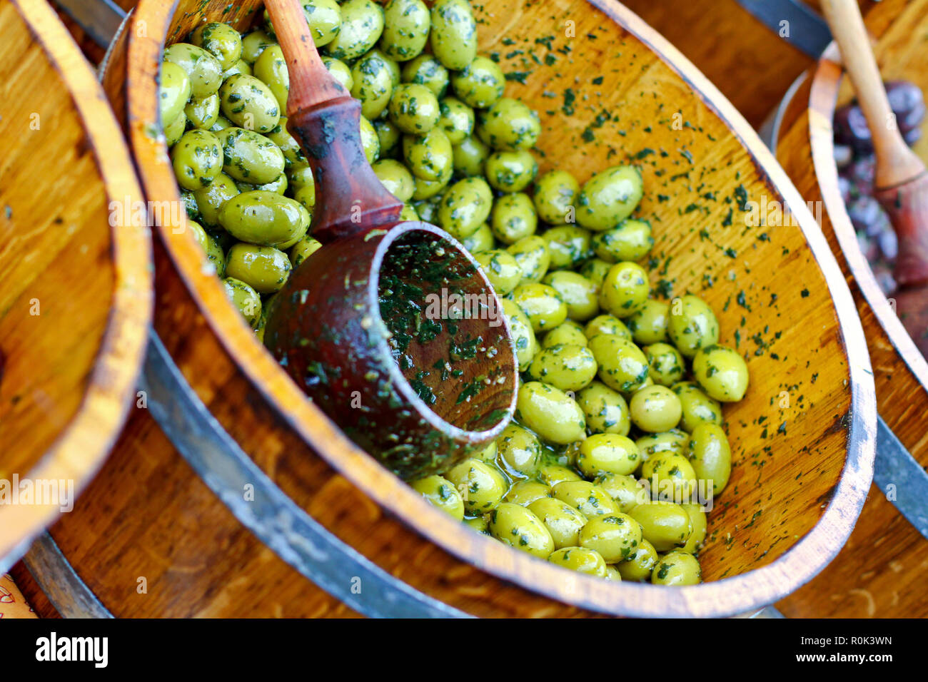 Green olives in wooden bucket sold on market Stock Photo - Alamy