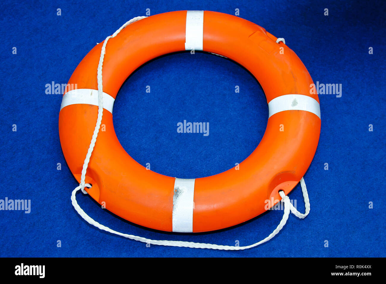 Florescent orange life buoy lifesaver at sea Stock Photo - Alamy