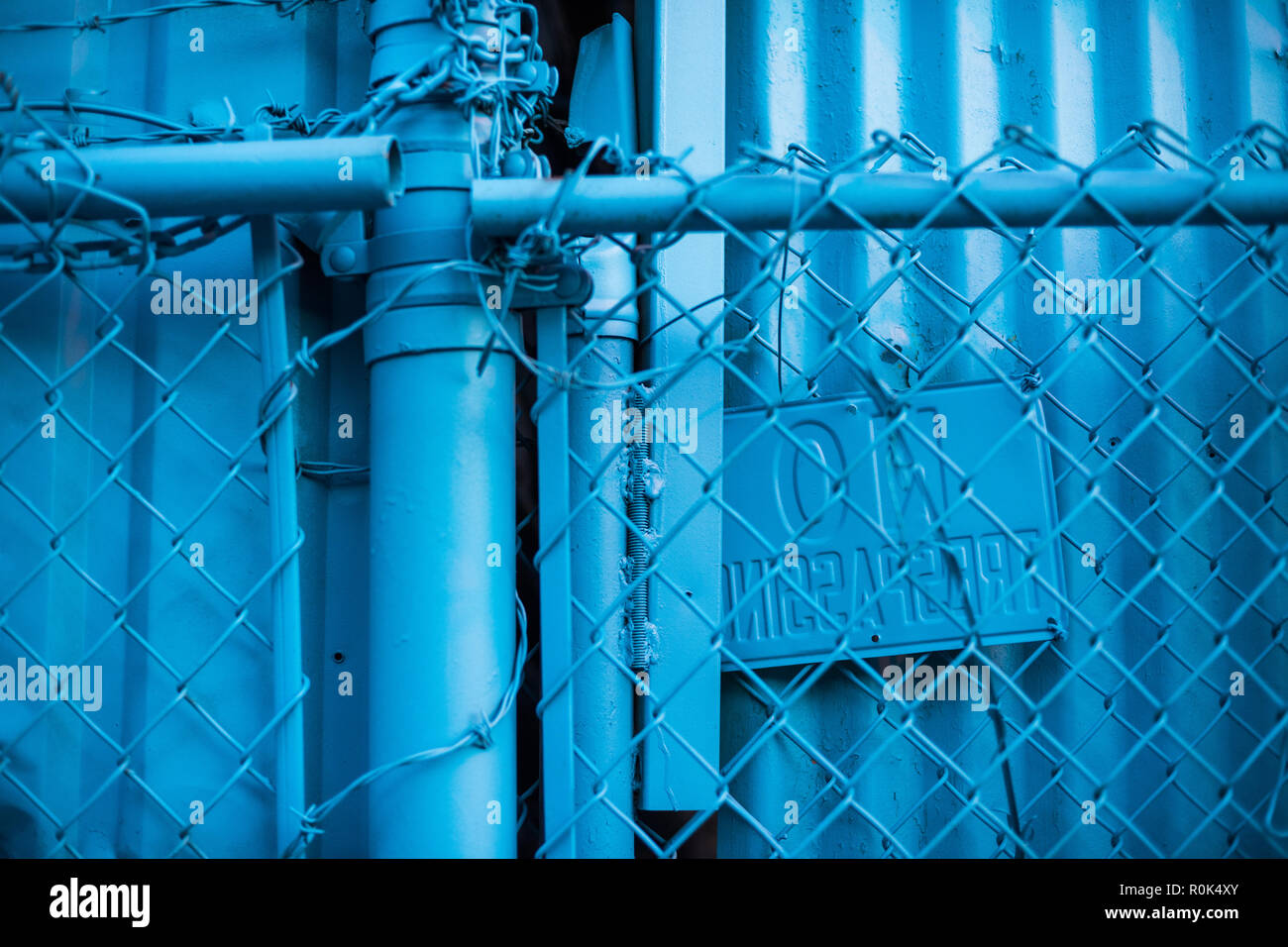 Blue fence with No Trespassing sign Stock Photo - Alamy