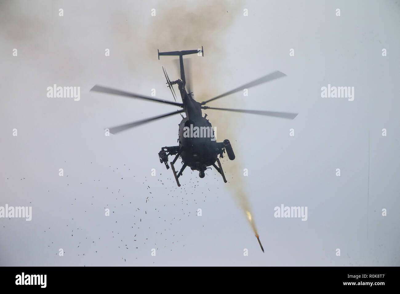 A U.S. Army AH-6 Little Bird helicopter firing rockets at target Stock ...