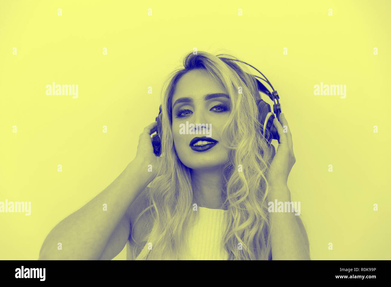 Portrait of a young woman singer with headphones. Listening to music ...