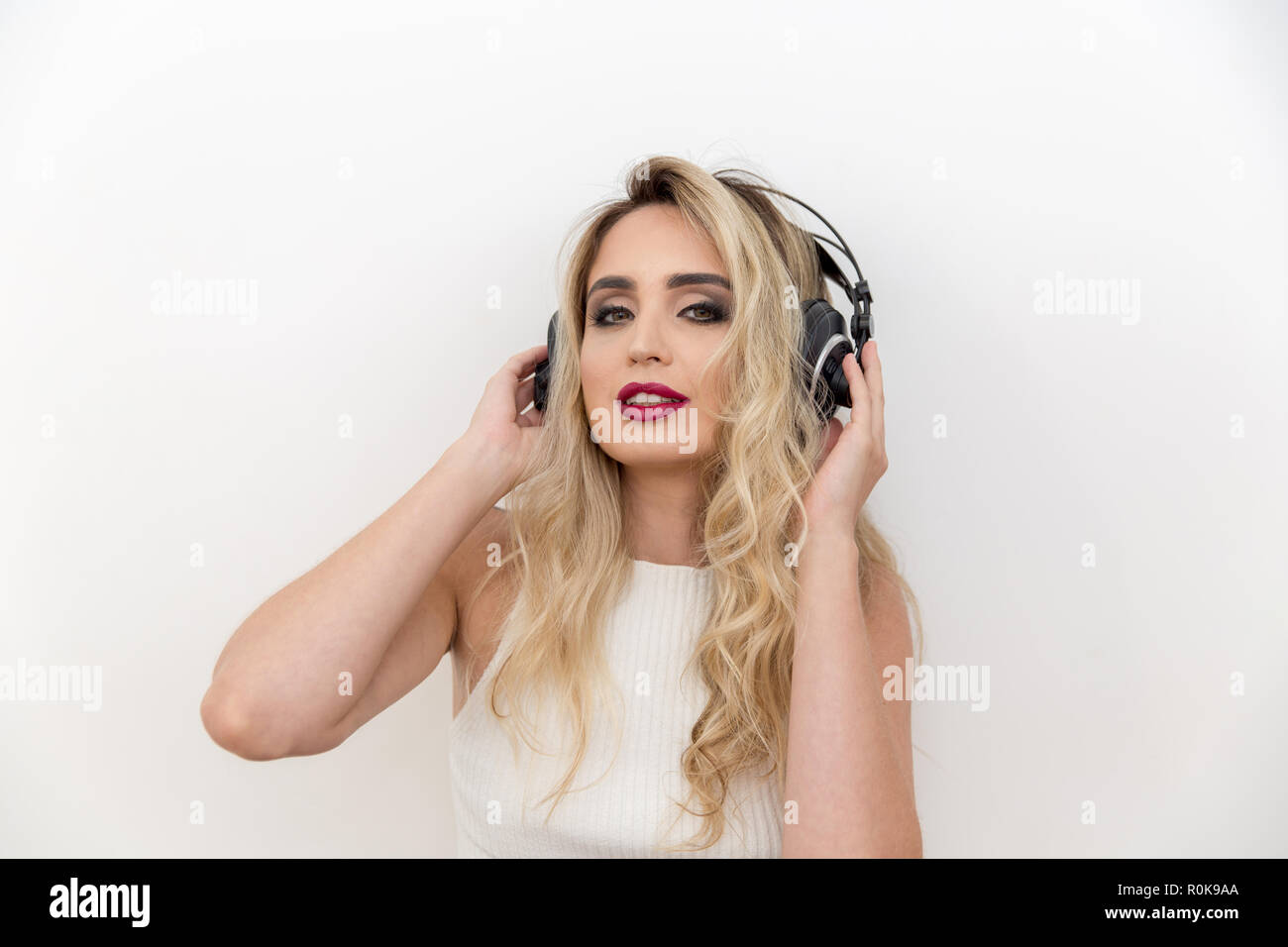 Portrait of a young woman singer with headphones. Listening to music ...