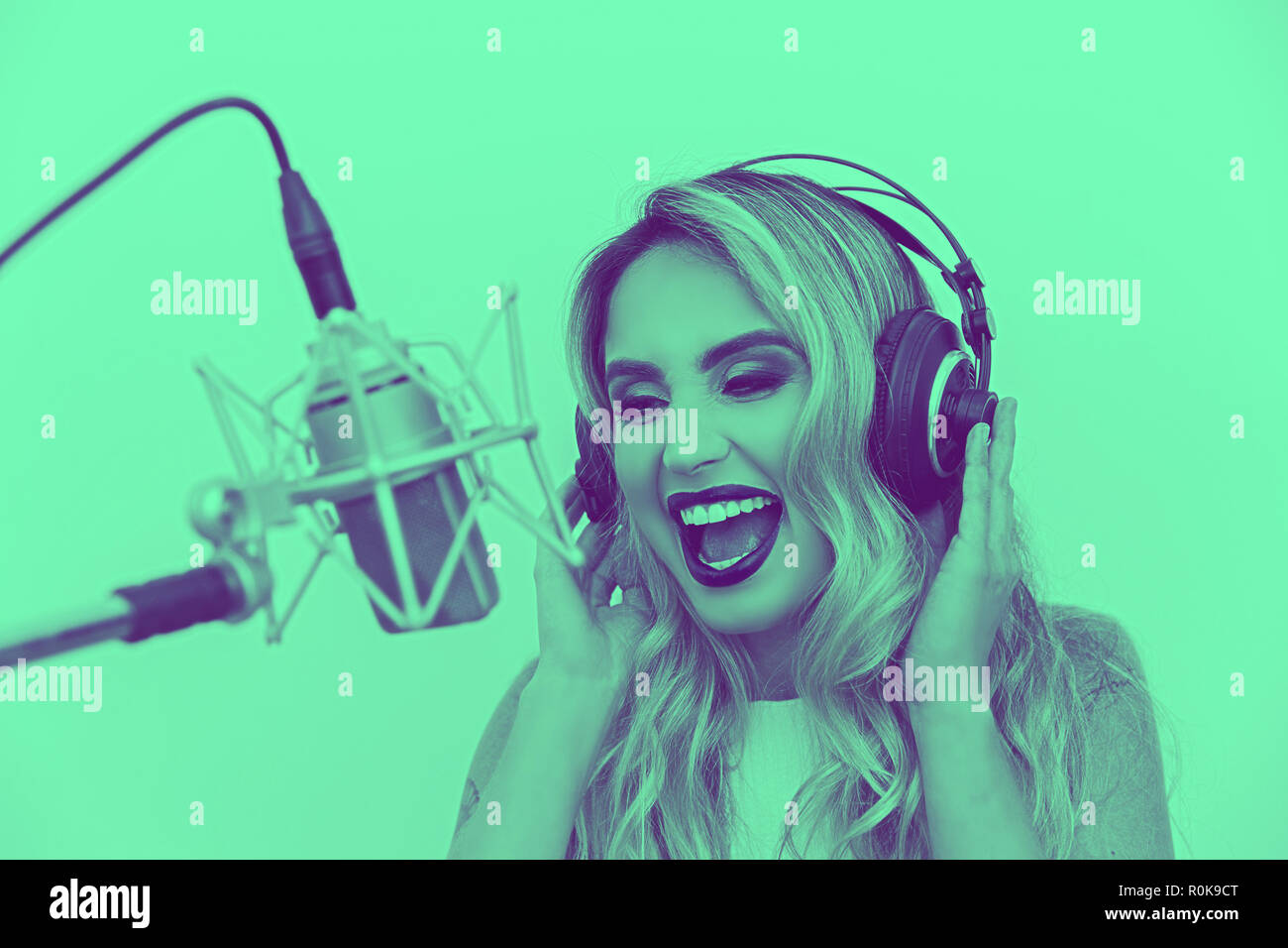 Portrait of a young woman singer with headphones in front of the ...
