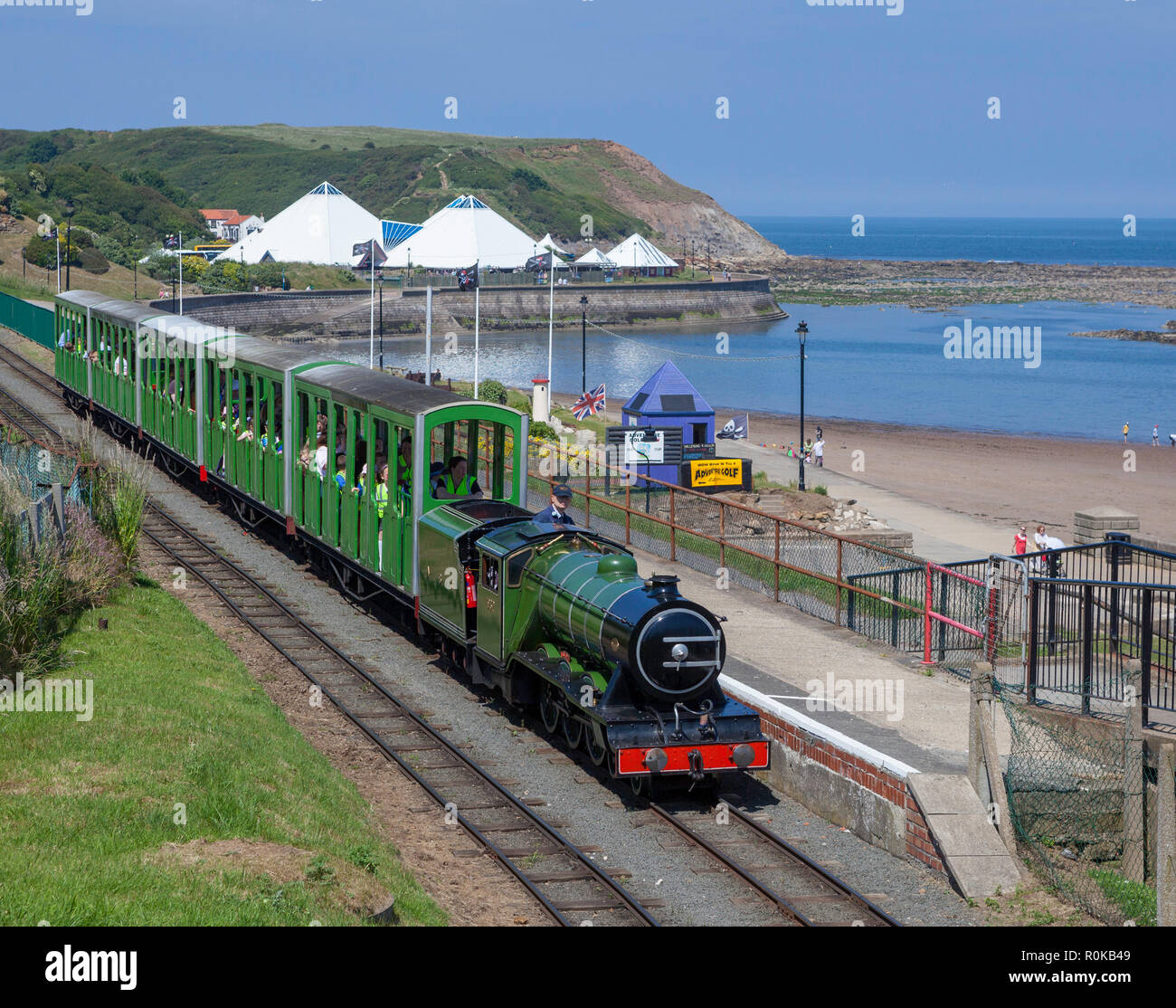 A miniature steam train pulls into a station on the North Bay Railway ...
