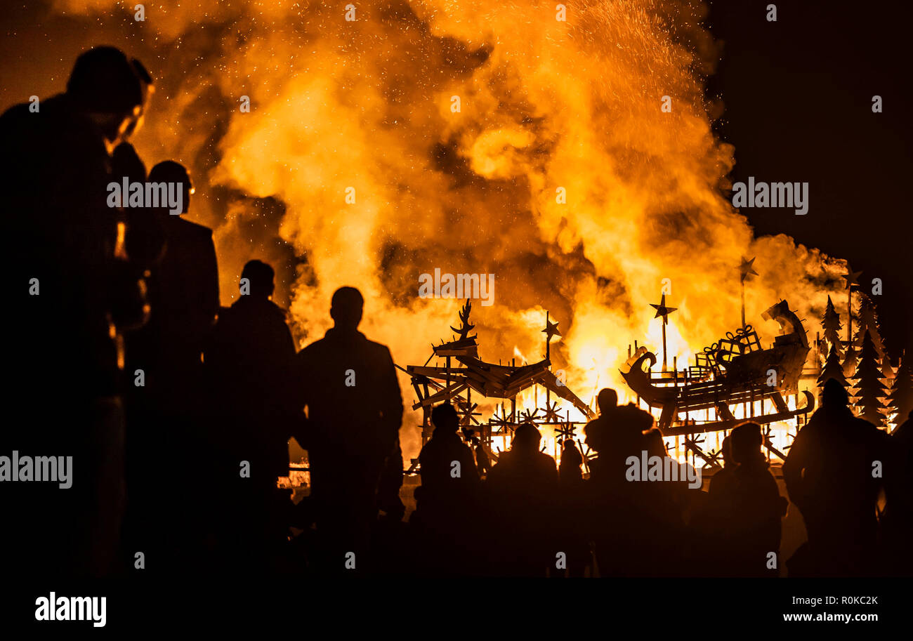 Members of the public view enjoy a bonfire in the shape of a Christmas ...