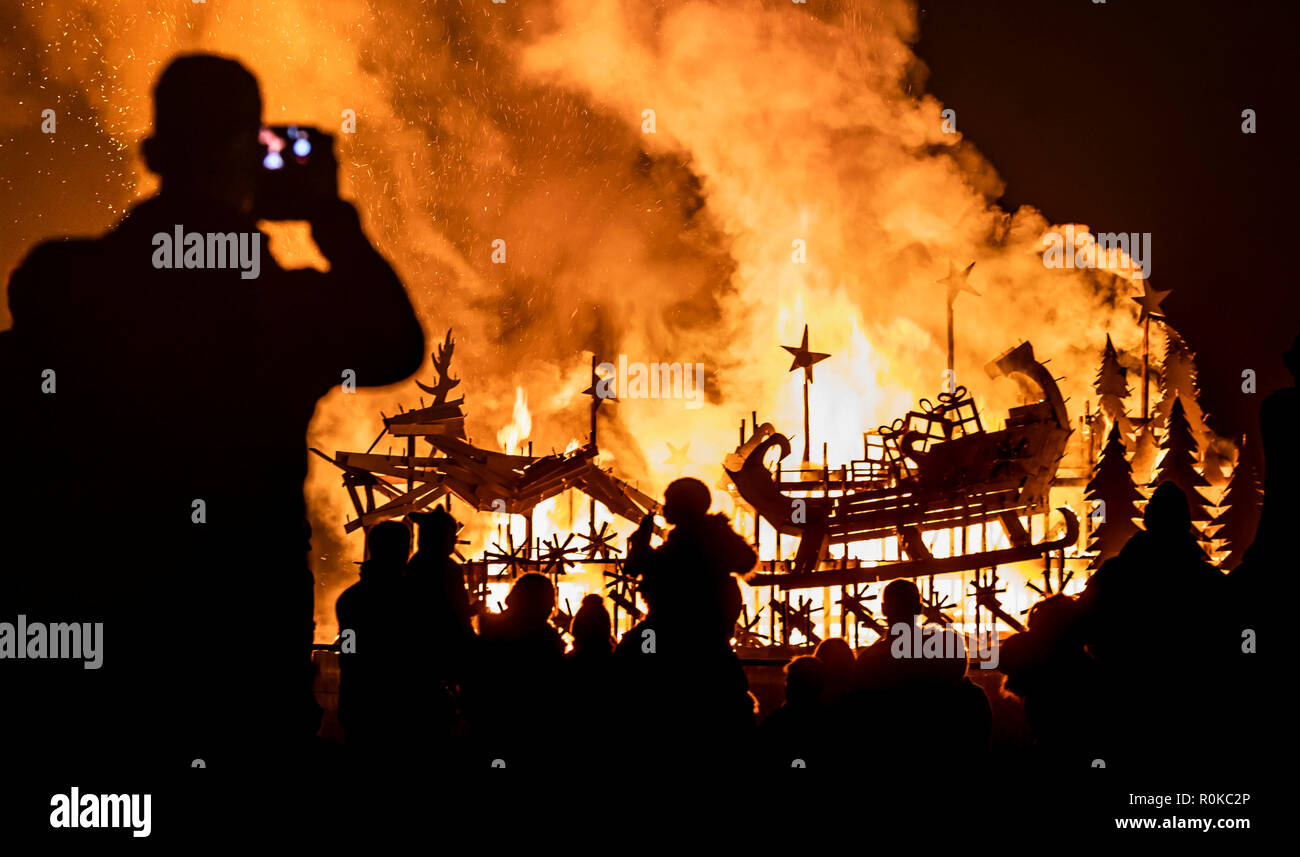 Members of the public view enjoy a bonfire in the shape of a Christmas ...