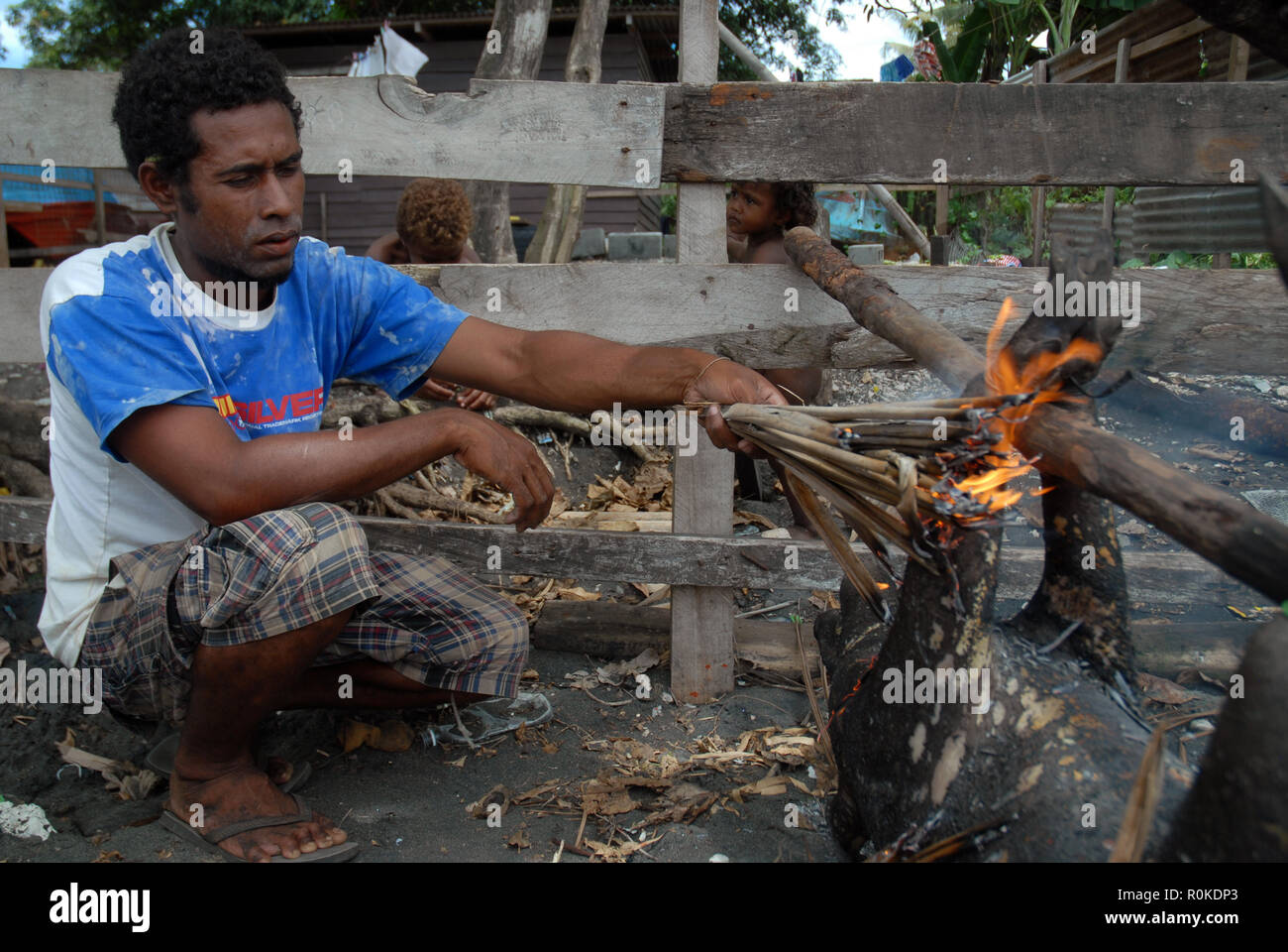 Man trying to start a fire to burn off the fur of a newly slaughtered ...