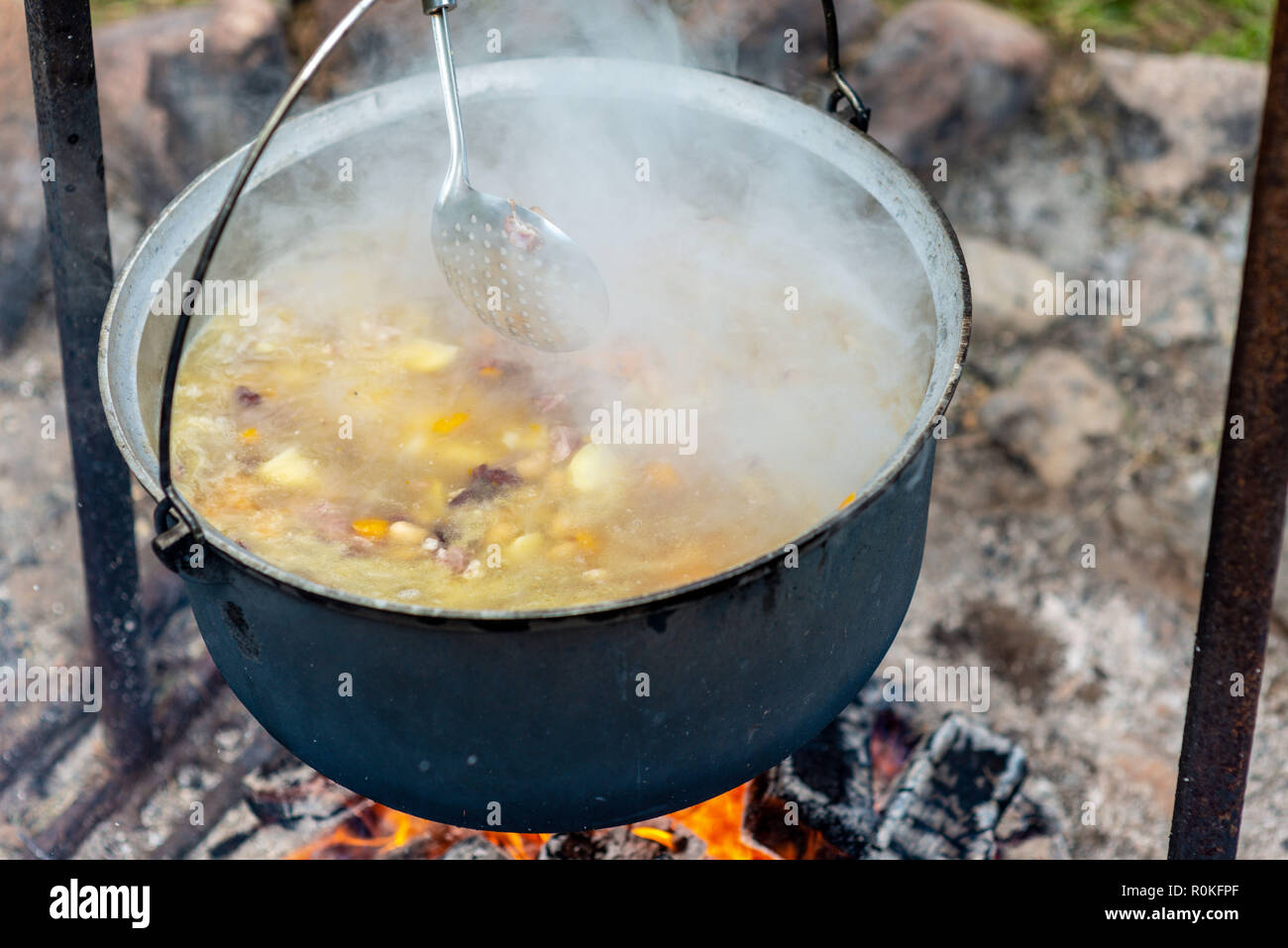 Cooking food in a pot on campfire. Summer camping concept Stock Photo ...